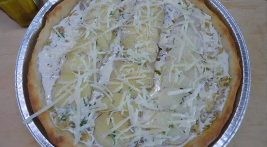 Onion cake with young potatoes, pour fill the pie and sprinkle with cheese