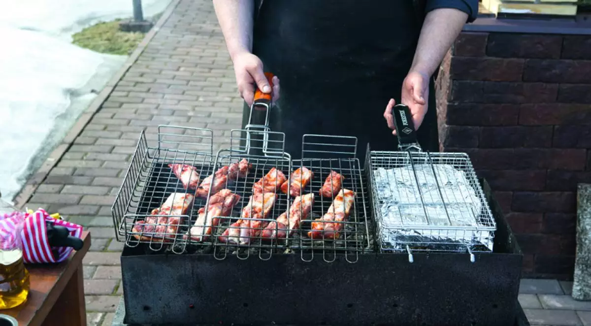 Meletakkan tulang rusuk babi pada satu grille, pada yang kedua - jagung