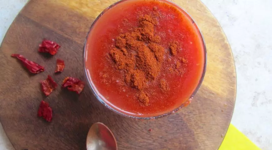 Meng de overgroeide tomaten met chili peper voor de bereiding van zeebaars