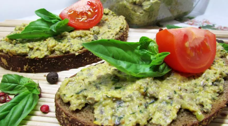 Serving Riet da zucchine con funghi su pane nero con fette di pomodoro