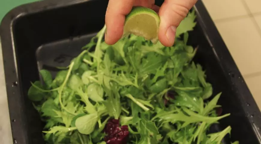 Comparte una verduras preparadas en un tazón de ensalada y vierta jugo de limón.