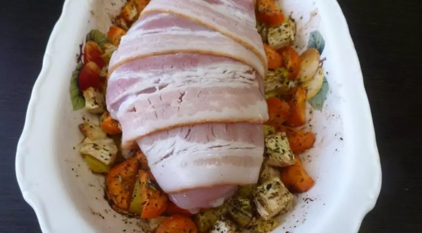 En la forma con verduras, ponga pechugas de pollo en tocino y envíe al horno.