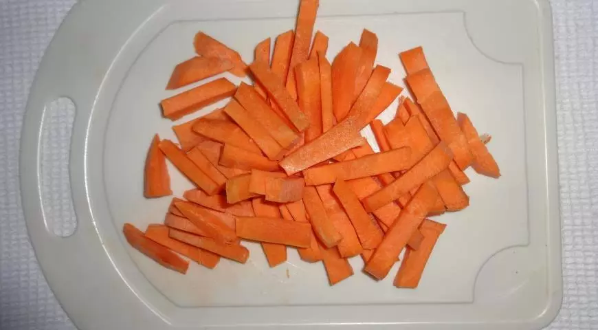 Corte las zanahorias para cocinar carne de cerdo guisada con verduras.