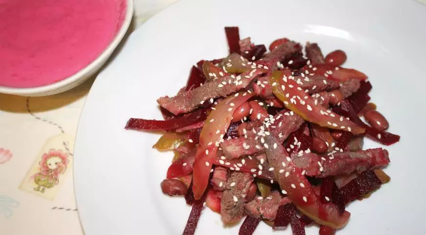 Salada com a língua sob molho com beterraba está pronta para arquivamento