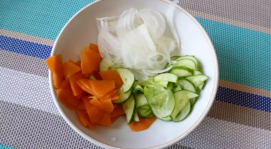 Cortar cebollas, pepinos y zanahorias para la ensalada de patata japonesa.