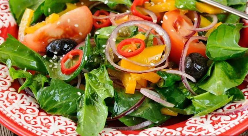 Salad terang dengan tomato, bayam dan sicilian mengisi minyak bersedia untuk memberi makan