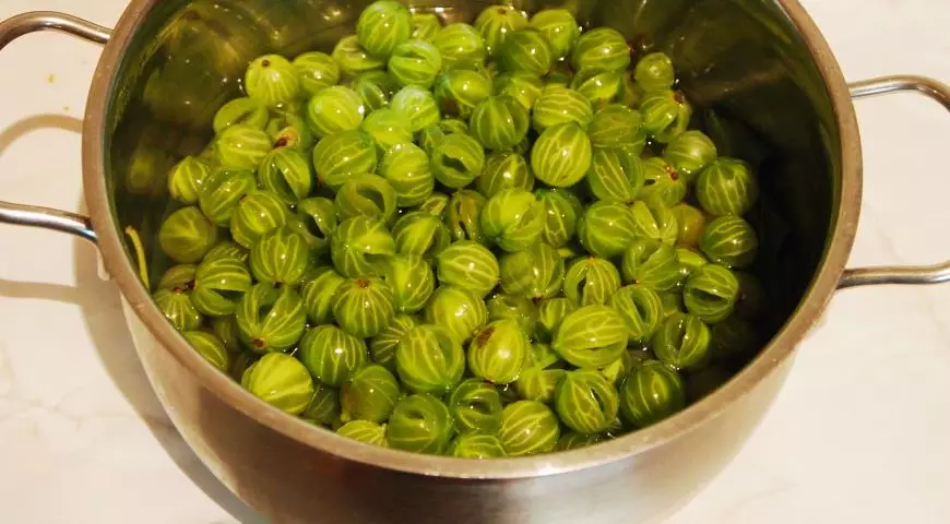 Tqegħid barra mill-gooseberry fil-saucepan għat-tisjir ġamm ambra