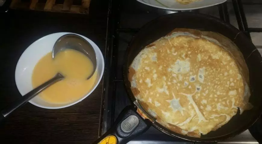Telur disebat dan goreng dalam pancake telur Pan