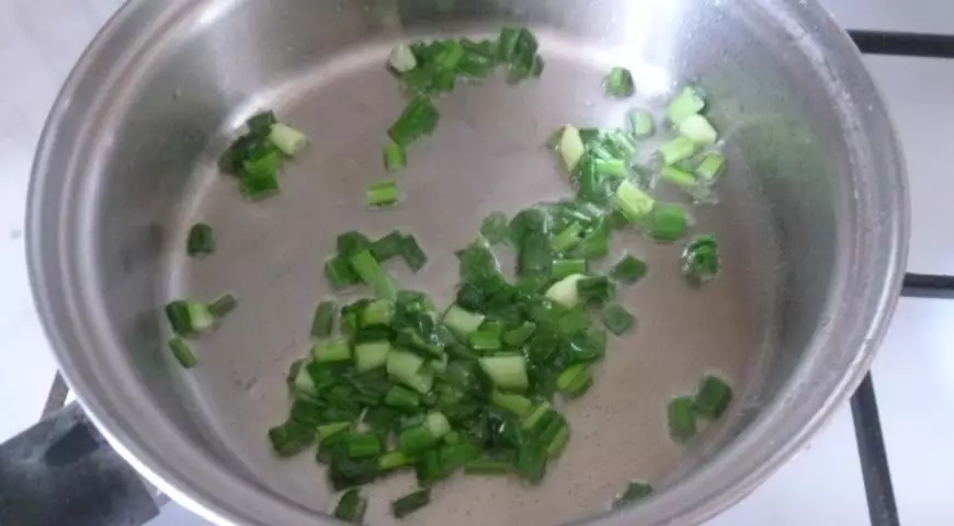 Фрай смачкан зелен лук на растително масло до мек