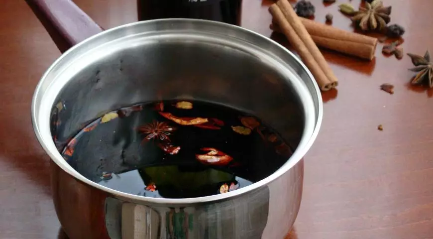 על ביצוע יין mulled לחלוט יין אדום עם תבלינים כתום חצי