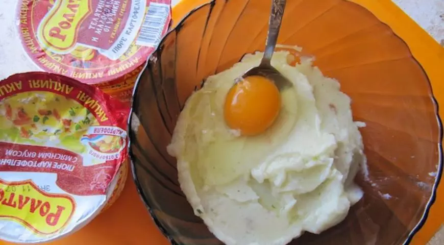 Fügen Sie ein Ei zu den fertigen Kartoffelkartoffeln hinzu