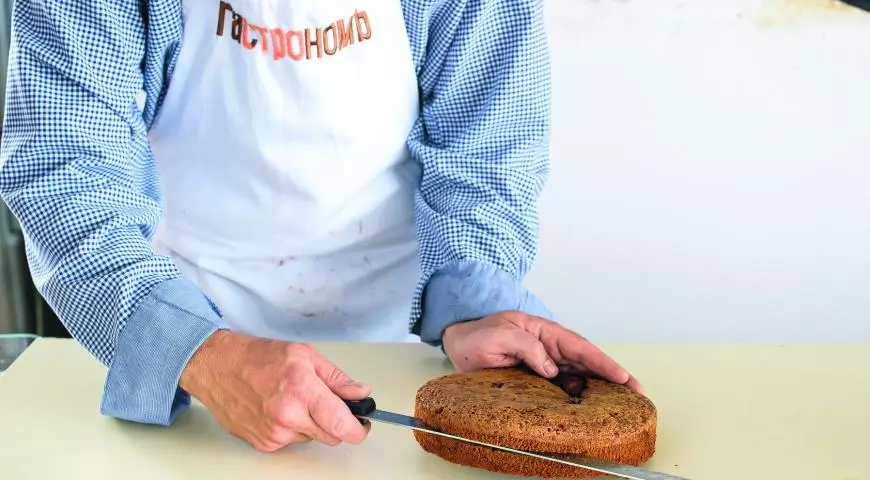 For decoration, melt chocolate and put in the pastry bag. Cut out a strip from the parchment with a width equal to the height of the cake, and the length equal to its circle. Apply the parchment pattern with a thin flower.