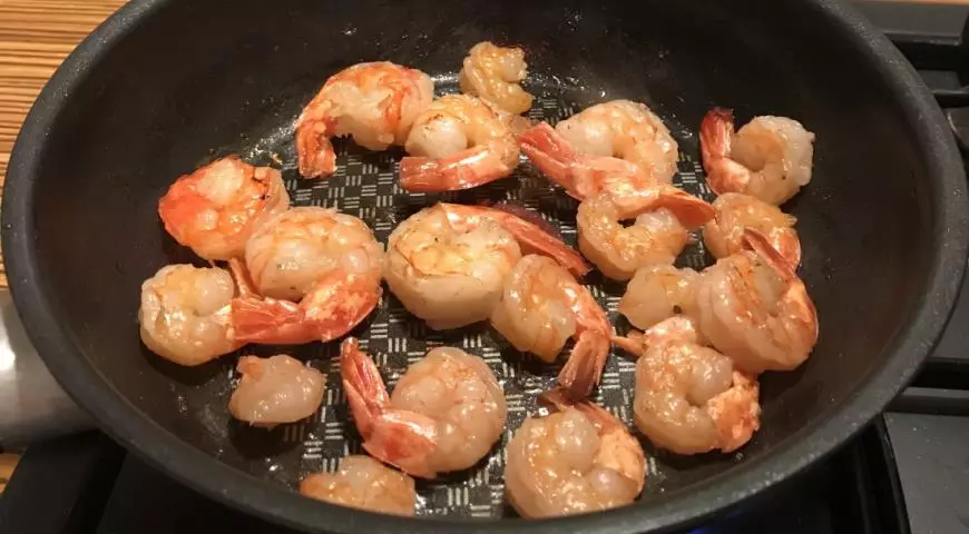 Kuandaa Bruschetta na tiger shrimps, nyanya na basil.