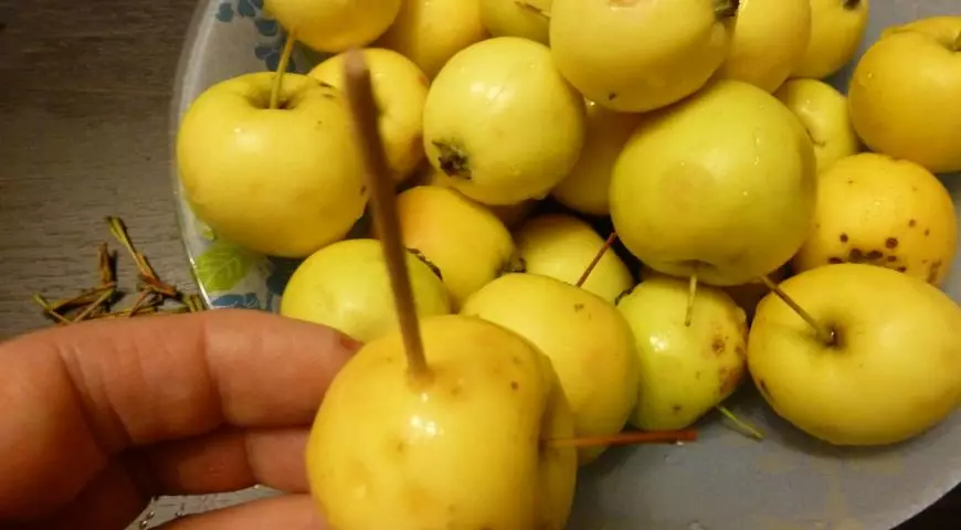 Wytnij ogonki z myjonych jabłek, przebijając wykałaczkę