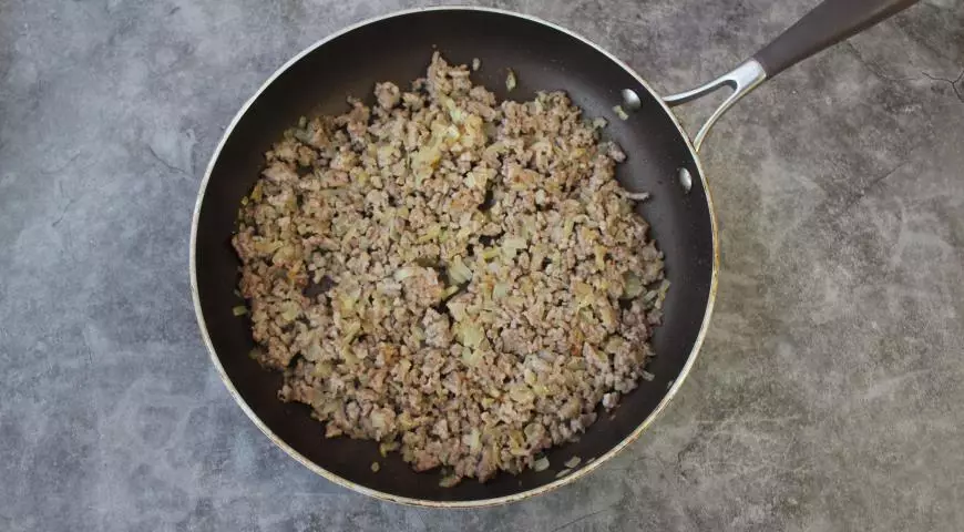 Fügen Sie dem Bogen Schweinefleisch-Hackfleisch hinzu und braten Sie sich vor dem Verdampfen von überschüssigen Feuchtigkeit