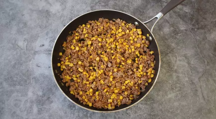 Mischen Sie Fleischfüllung für Tacos mit Tomatensauce und Coded Corn