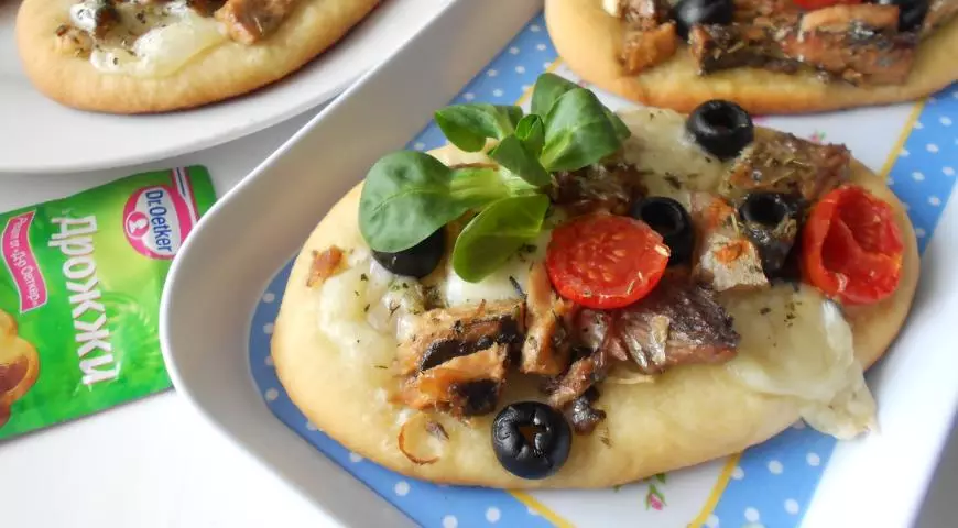 Koken mini pizza met saury, mozzarella en olijven