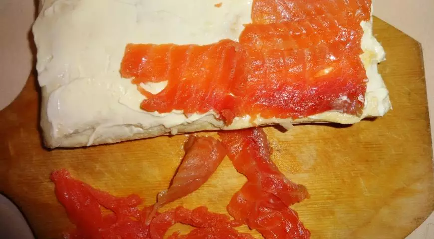 Leg fijn gesneden zwak gezouten zalm op een taart met boter