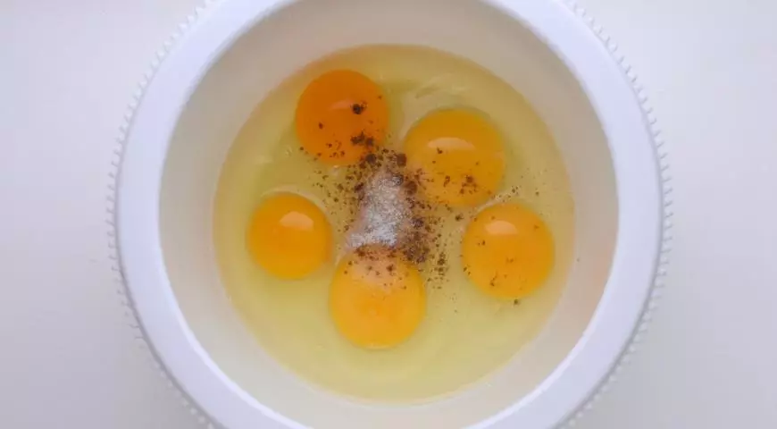 Į kiaušinius įpilkite druskos ir pipirų