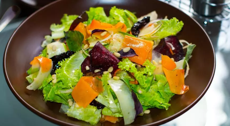 Forbereder salat med vegetabilske chips og græskar