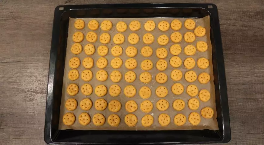 Rôlje oer it daai yn 'e laach en snij in rûnfoarmige koekje, meitsje gatten