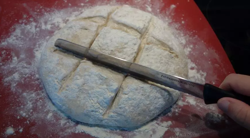 พื้นผิวของขนมปังถูกโรยด้วยแป้งและตัด