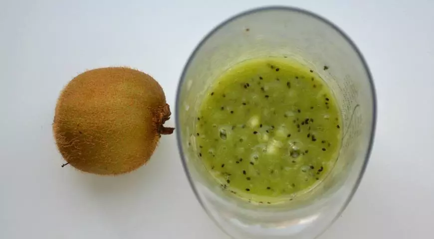 Grind kiwi med sukker for matlaging av fruktis