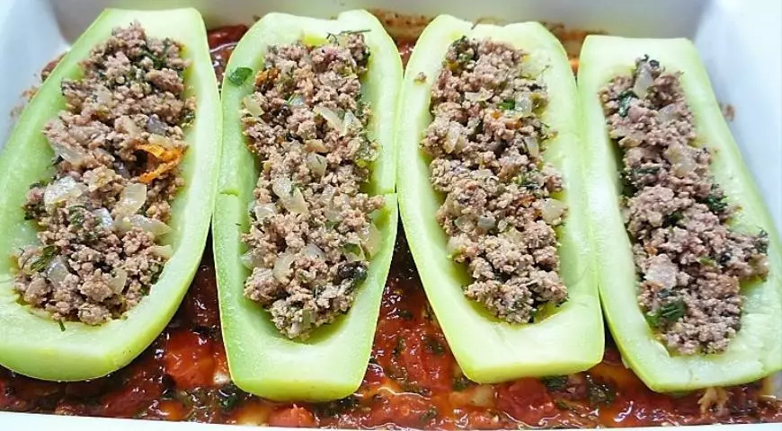 On tomato sauce, we put the boats from the zucchini, add mince top