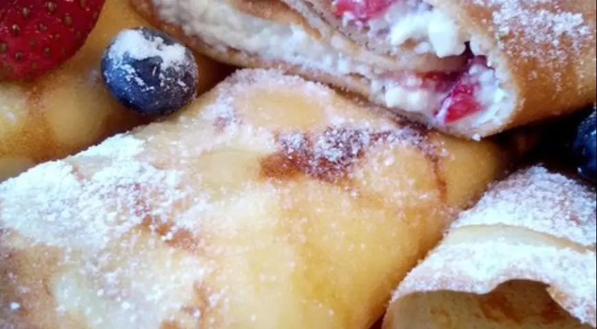Cucinare i pancake dolci con il riempimento da ricotta e frutta