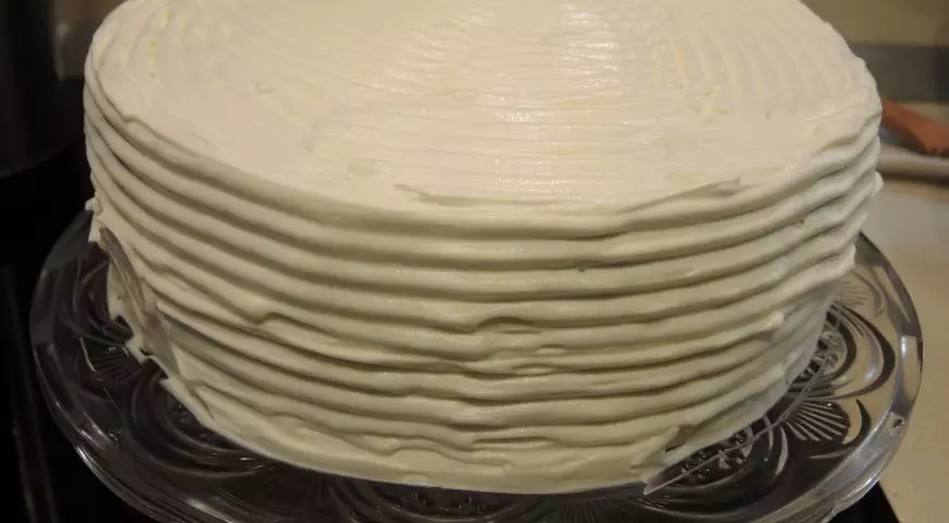 Baki krim melancarkan bahagian atas dan sisi kek rafaello