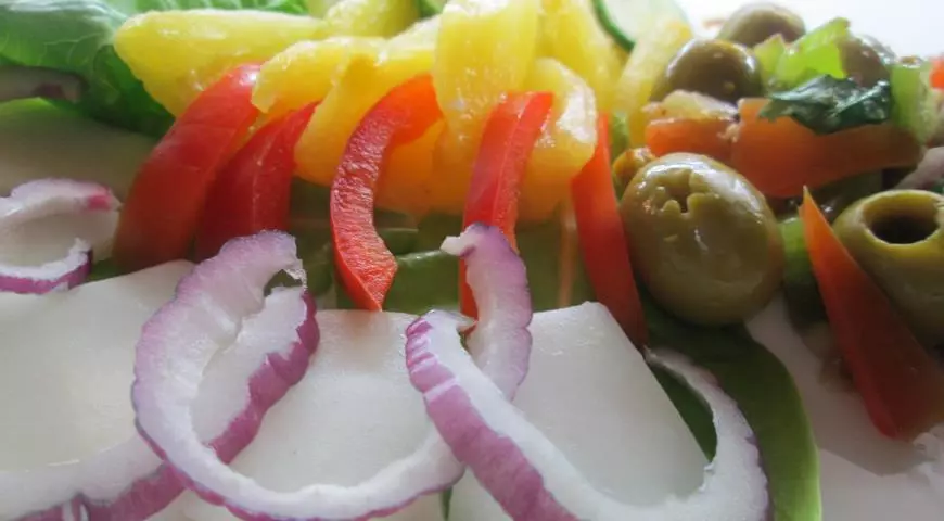 Salade fan fruit en griente lei op it skûtel, pour pittige saus