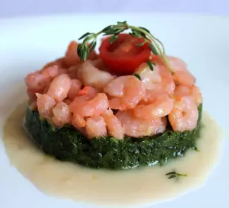 Shrimps a cikin miya mai tsami a kan matashin kai na alayyafo