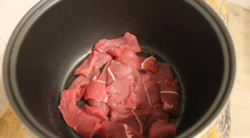 Corte a carne para a preparação de Borscht e coloque uma tigela multicooker