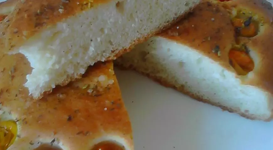 La focaccia con tomates cherry está lista para la alimentación.