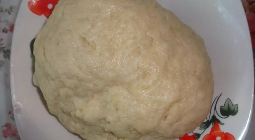 Pour vegetable oil into dough, put for one hour in a warm place