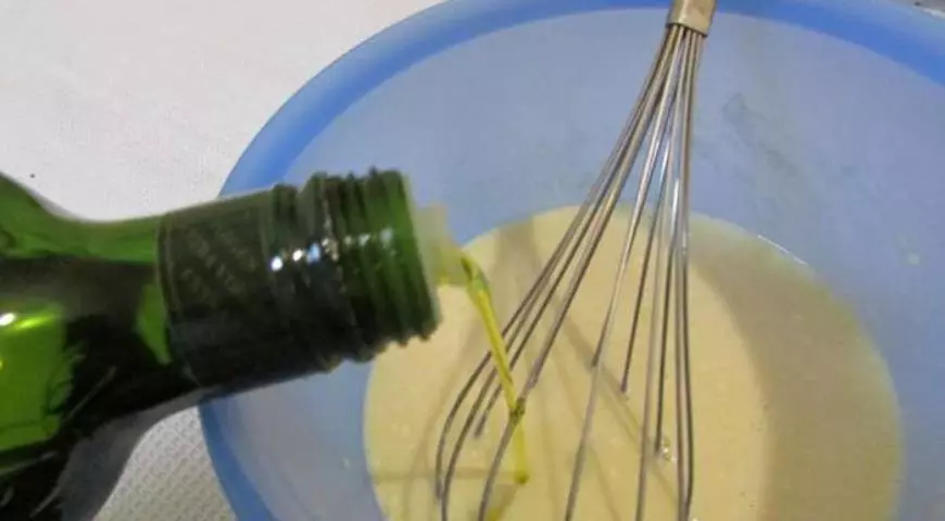 Fügen Sie Olivenöl in den Teig hinzu und schlagen Sie
