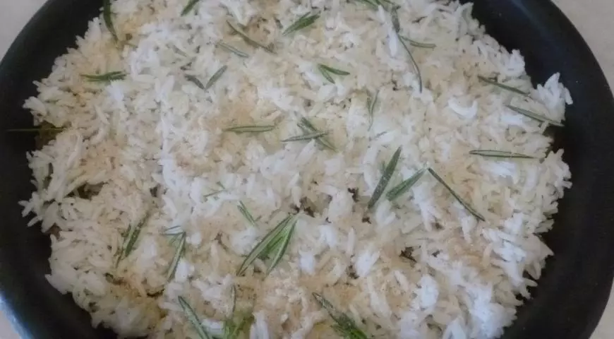 Em seguida, coloque arroz e polvilhe com folhas de alecrim e queijo