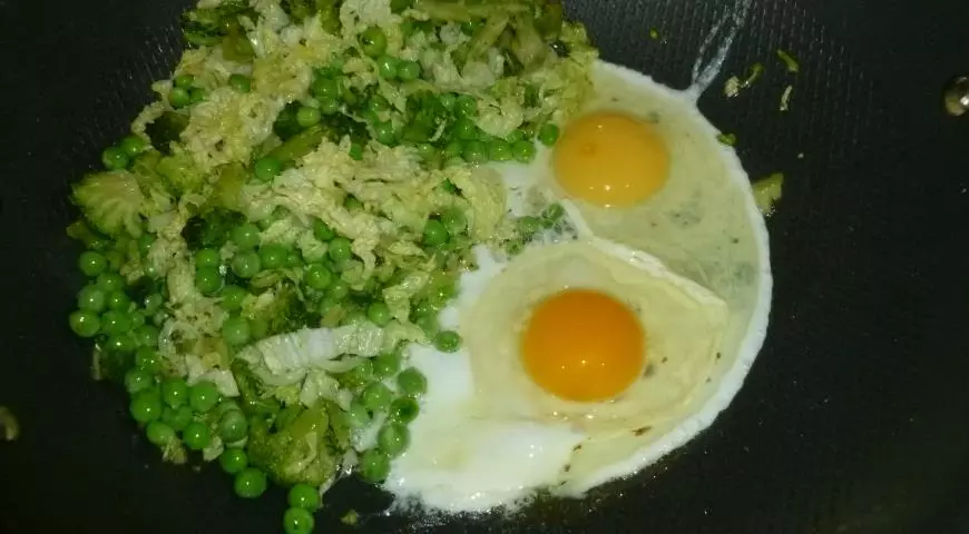 Sayur-sayuran goreng dengan telur di wajan