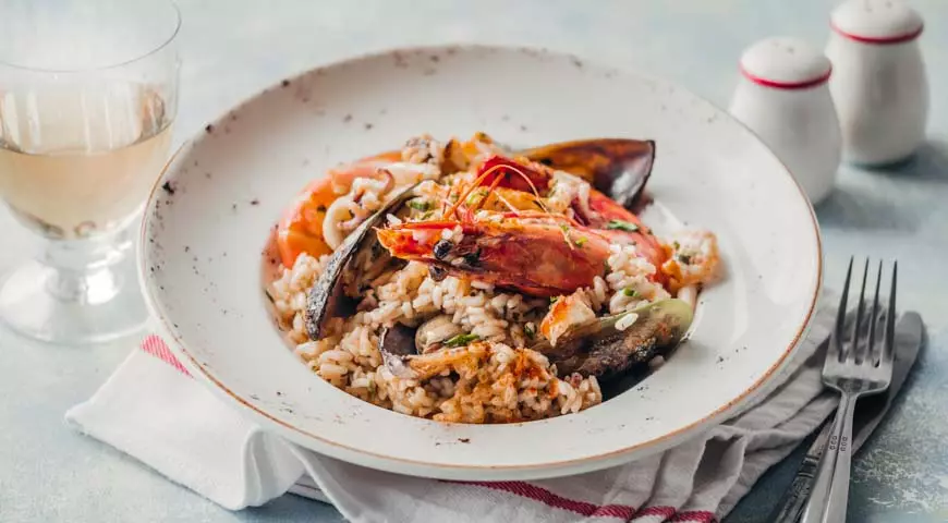 Risotto me ushqim deti, vendosni një risotto me ushqim deti në një pjatë të nxehtë