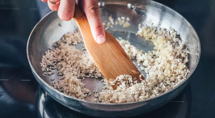 Risotto met zeevruchten, giet droge rijst voor risotto