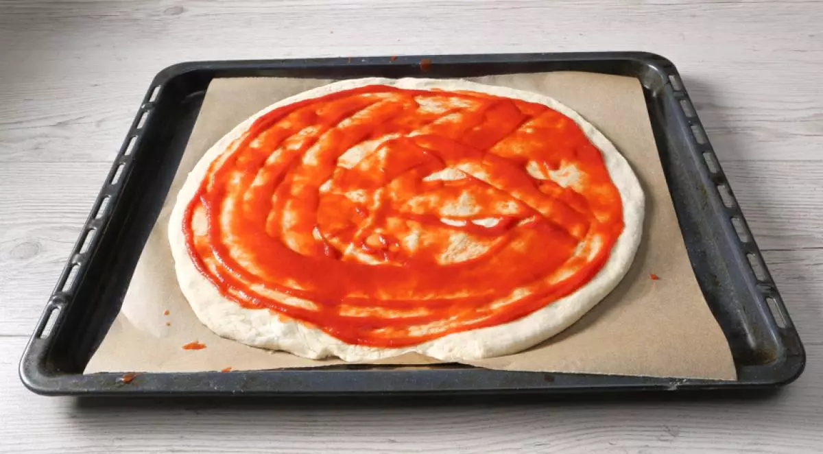 Pizza so šunkou a hubami, mazanie pizzu