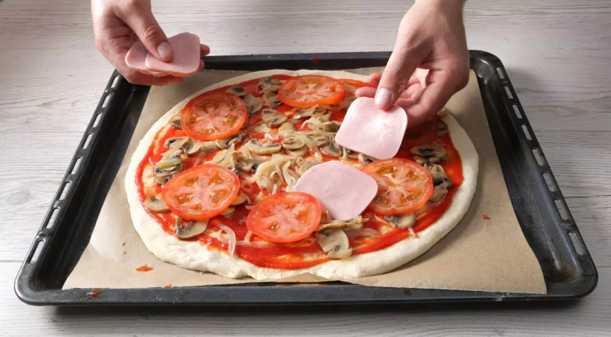 Pizza so šunkou a hubami, vyložte paradajky a šunku