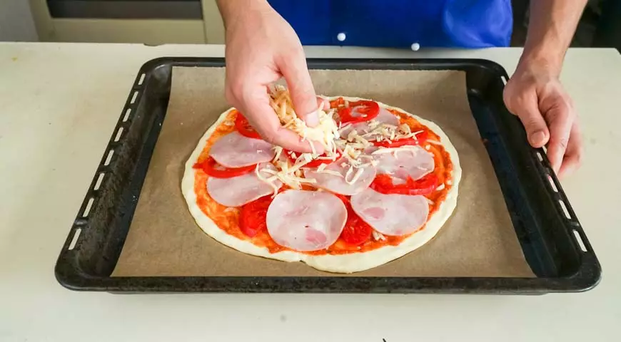 Pizza op Kefir, expropress Ham an Tomaten uewen, sprëtzen mat Kéis