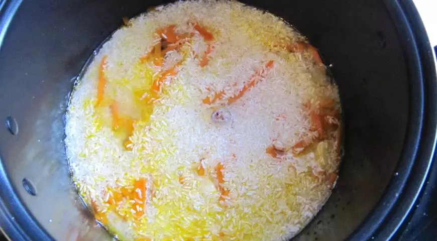 سوڈے گوشت چاول گر، لہسن کے سر داخل کریں اور پائلف کو تیاری میں لائیں