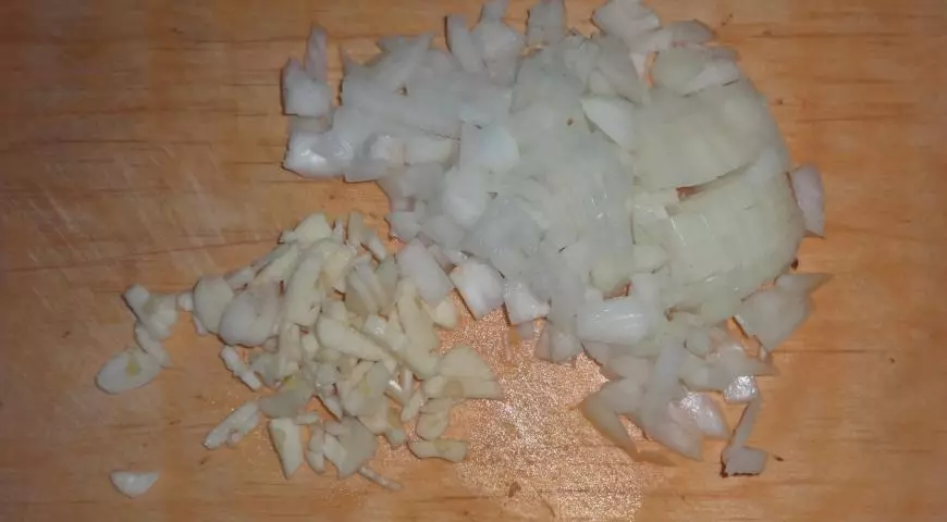Memotong bawang dan bawang putih untuk sup sayur