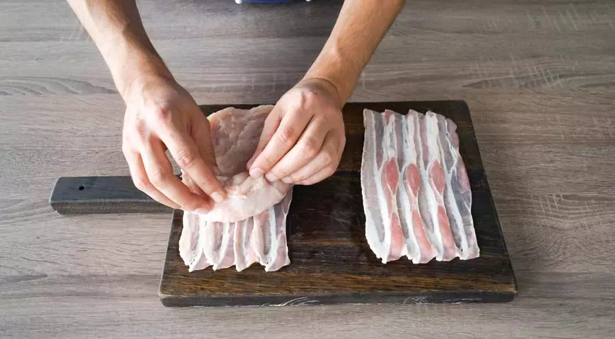Aus gekollt Pouletrollen ënner dem Moschterzooss, mat Bacon schneiden d'Haut an setzt 3 Schlieder op engem Schneidegplat, setzt e Poulet Broscht vun uewen