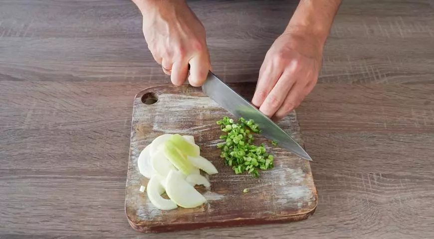 Forshmak de Arenque, corte la cebolla y las cebollas verdes.